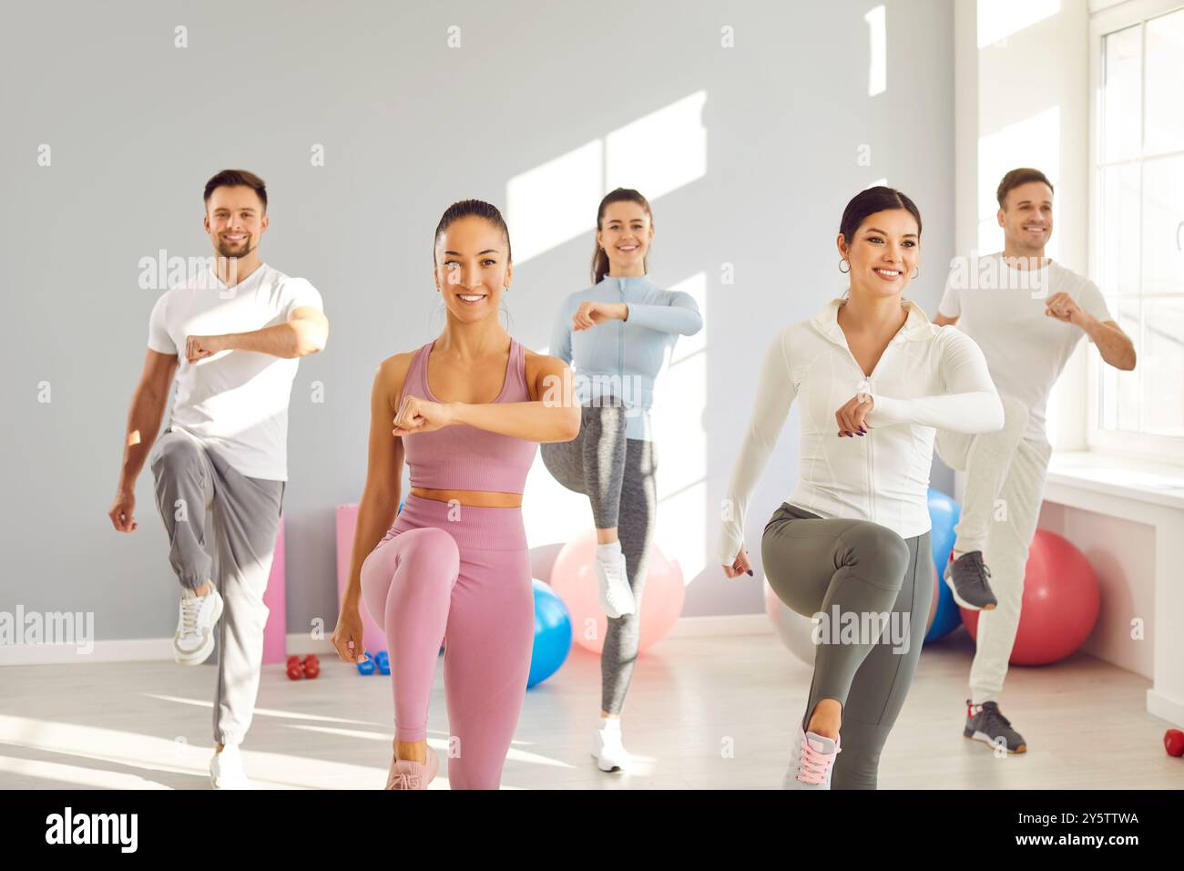 Group of fit and active group of people doing sport exercises in gym ...