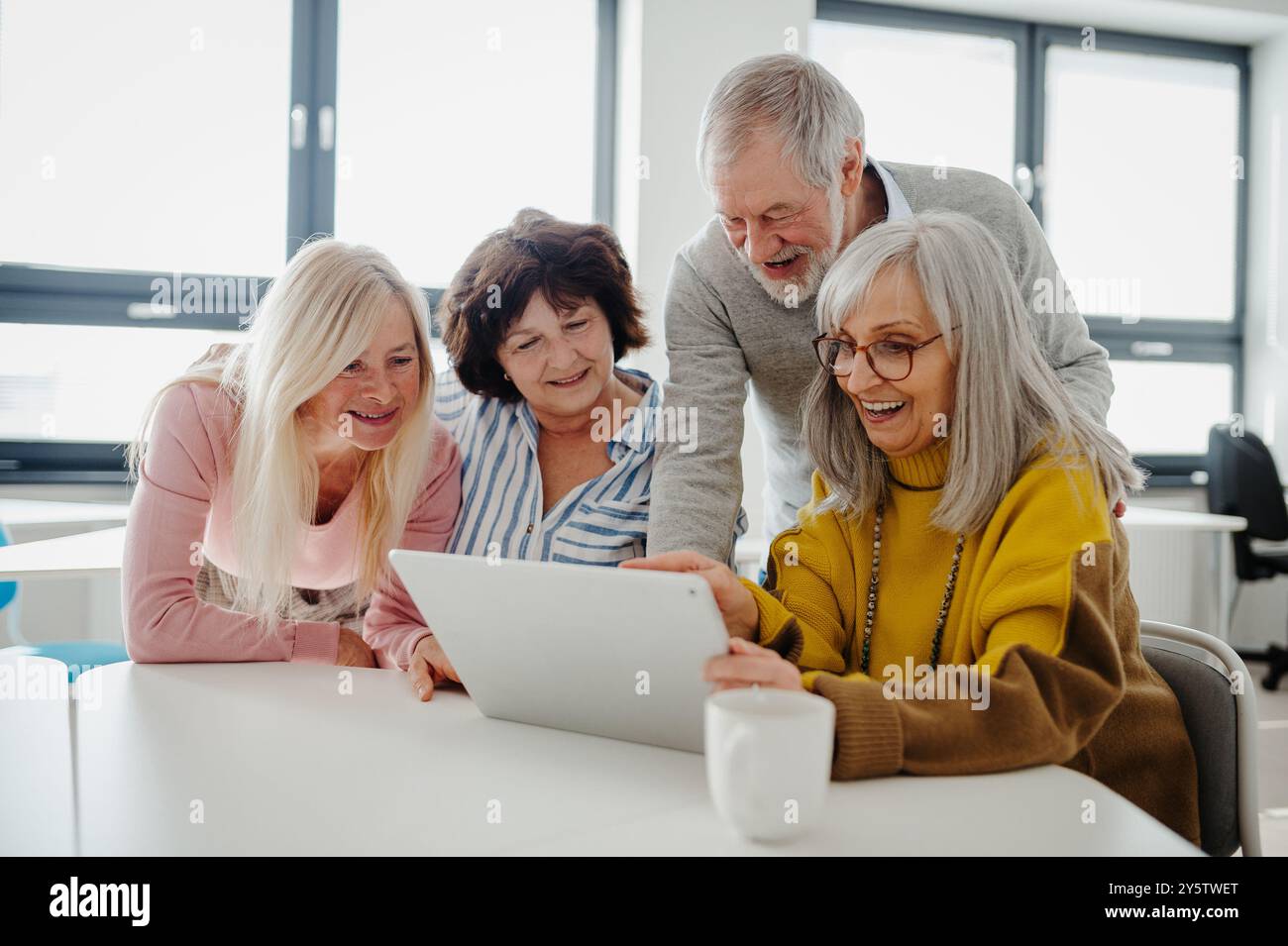 Group of senior students looking at tablet screen, learning new skill ...