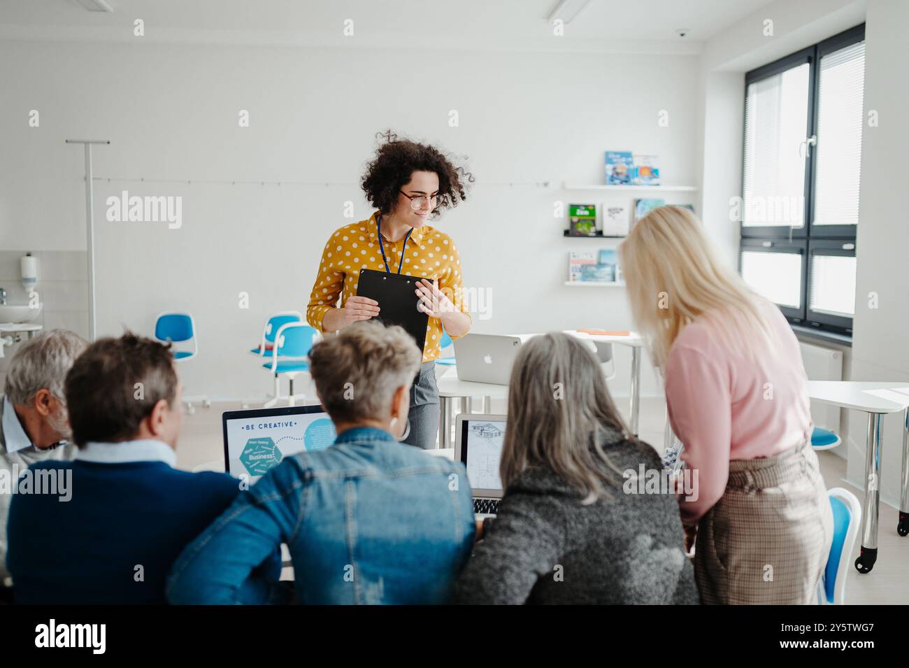 Teacher explaining senior students how to start their own business ...