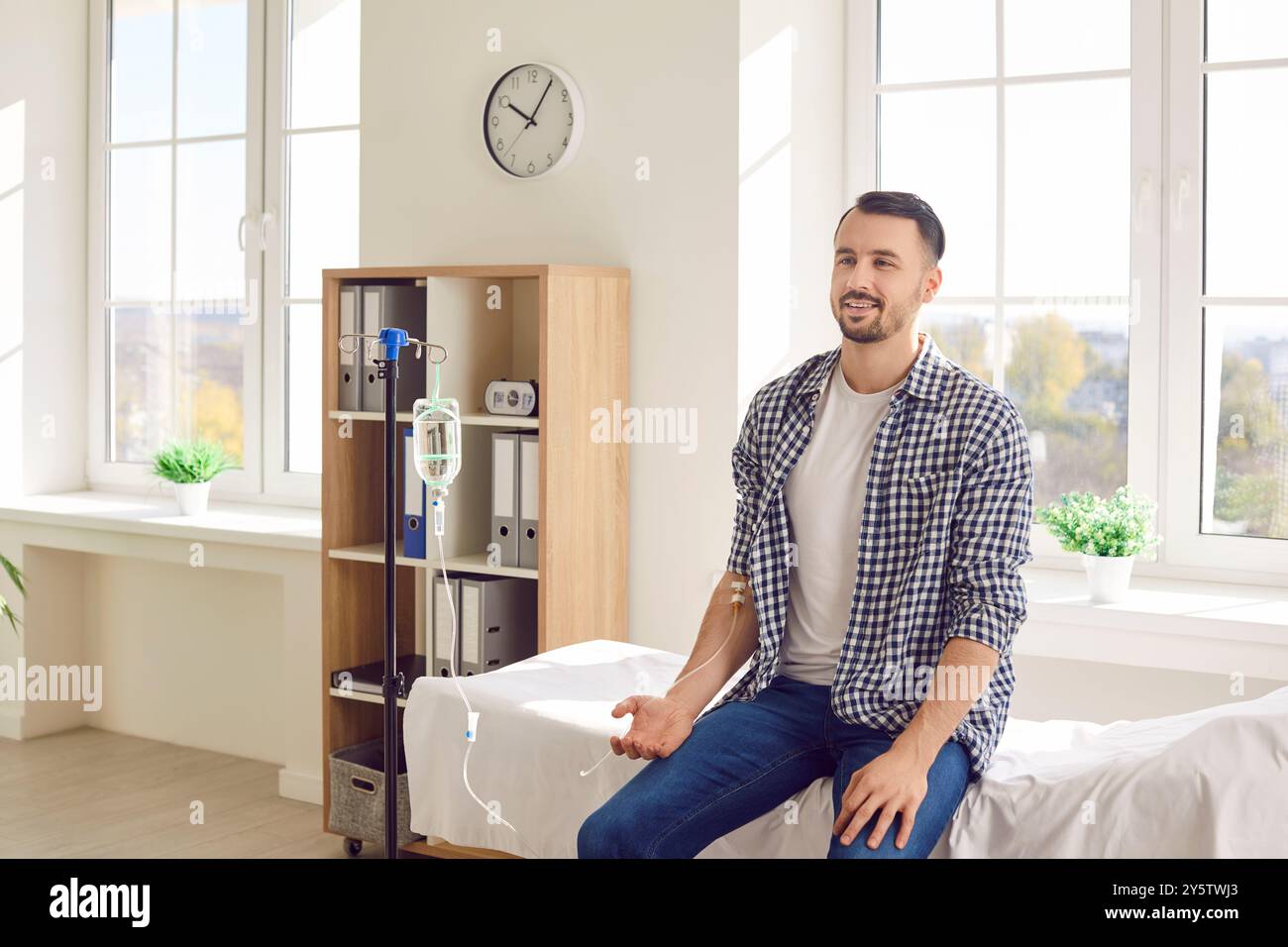 Young happy man receiving IV drip infusion and vitamin therapy in ...