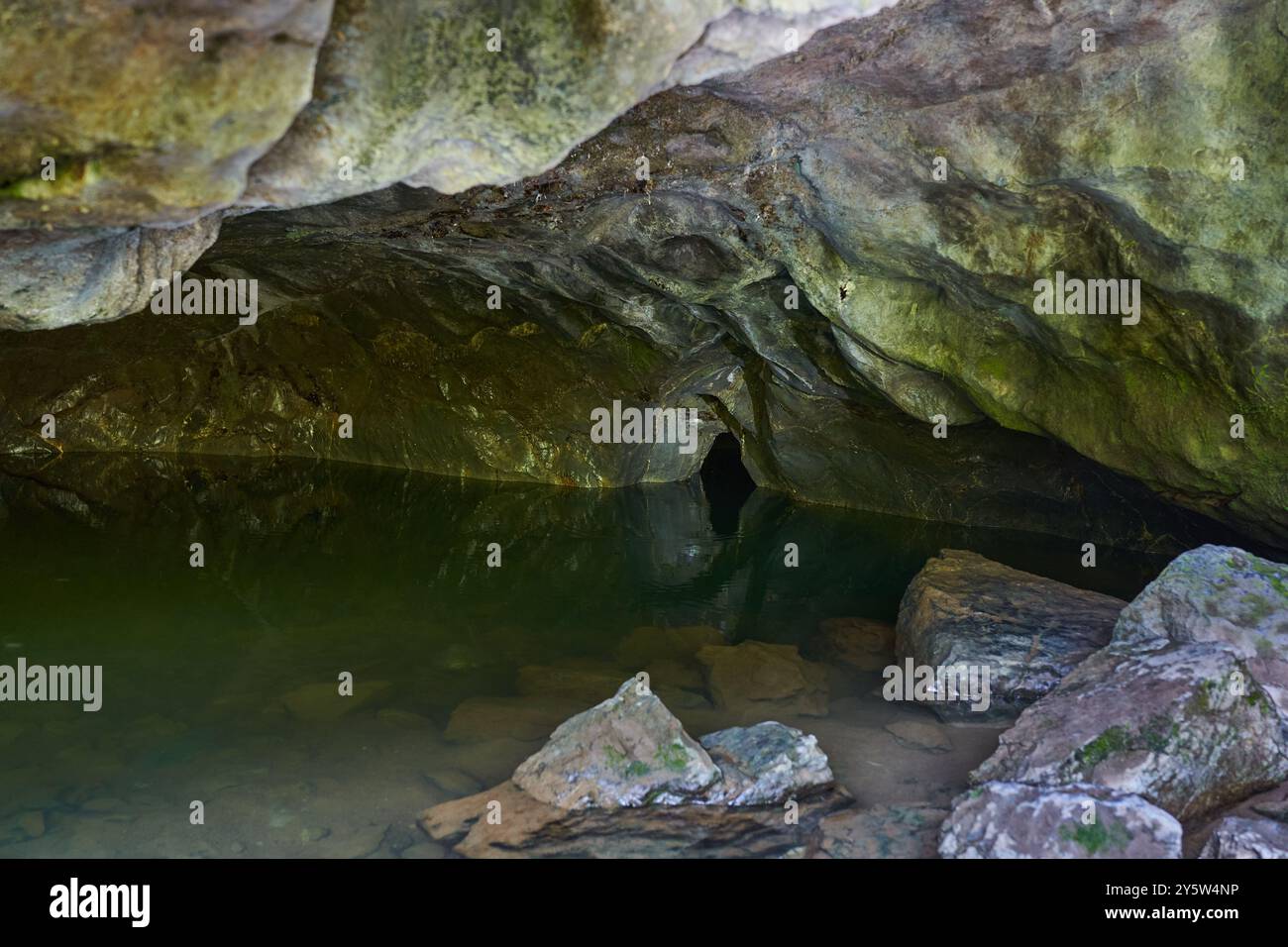 Karstic spring in a cave in the limestone mountains, feeding a river ...