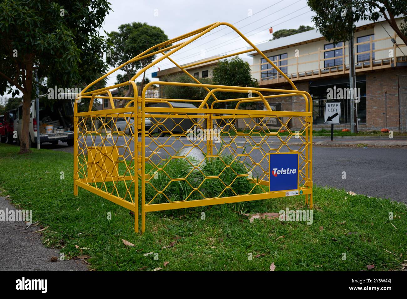 Yellow metallic cage or barrier, featuring Telstra logo, protecting ...