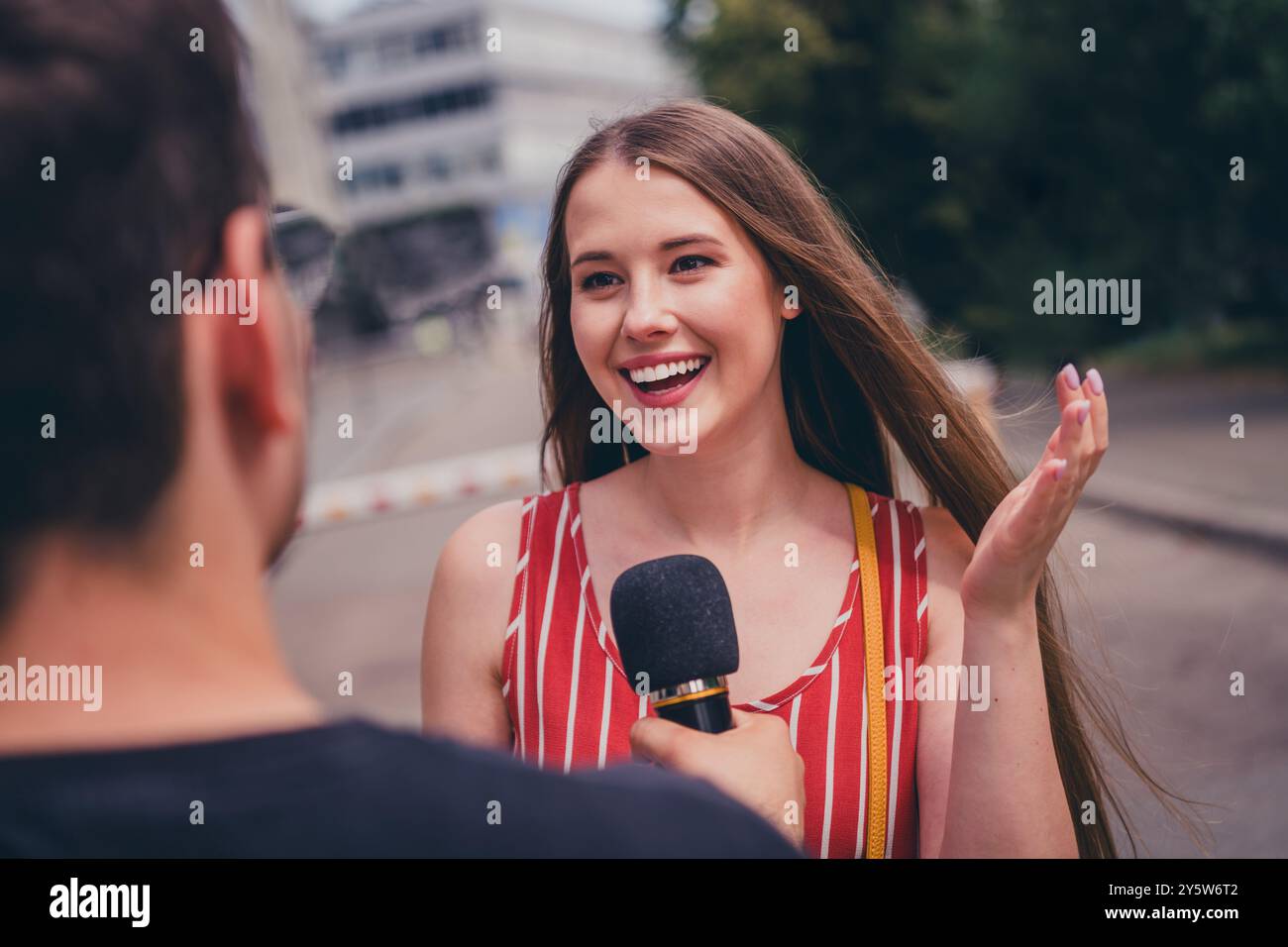 Photo of charming girl giving interview to journalist speaking in ...