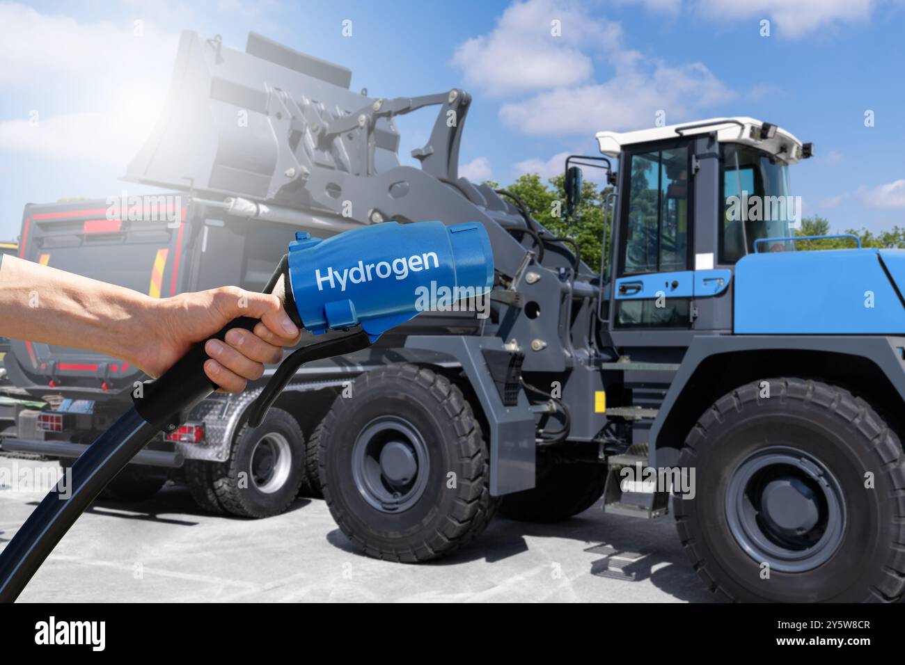 Hand with hydrogen fueling nozzle on a background of fuel cell ...