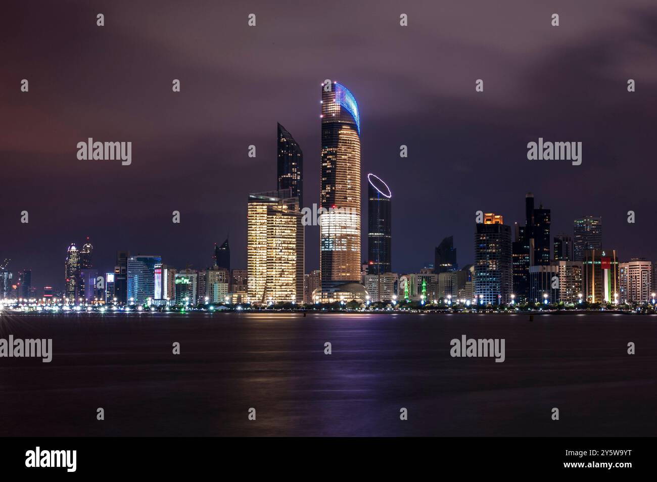 Night view of Abu Dhabi Corniche. Bright skyline with colorful lights ...