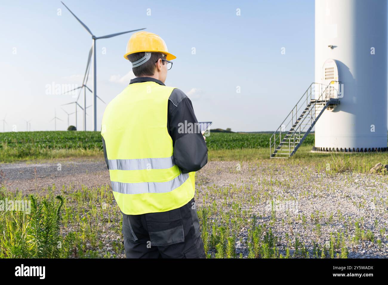 Engineer with digital tablet works on a field of wind turbines Stock ...
