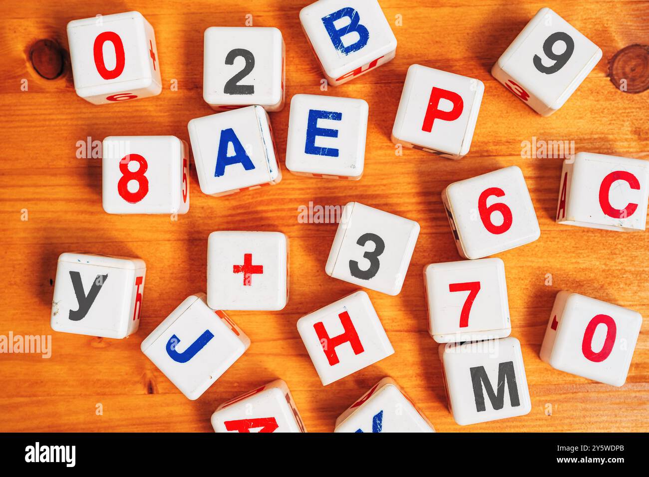 Learning letters and numbers, top view of plastic cubes on wooden desk ...