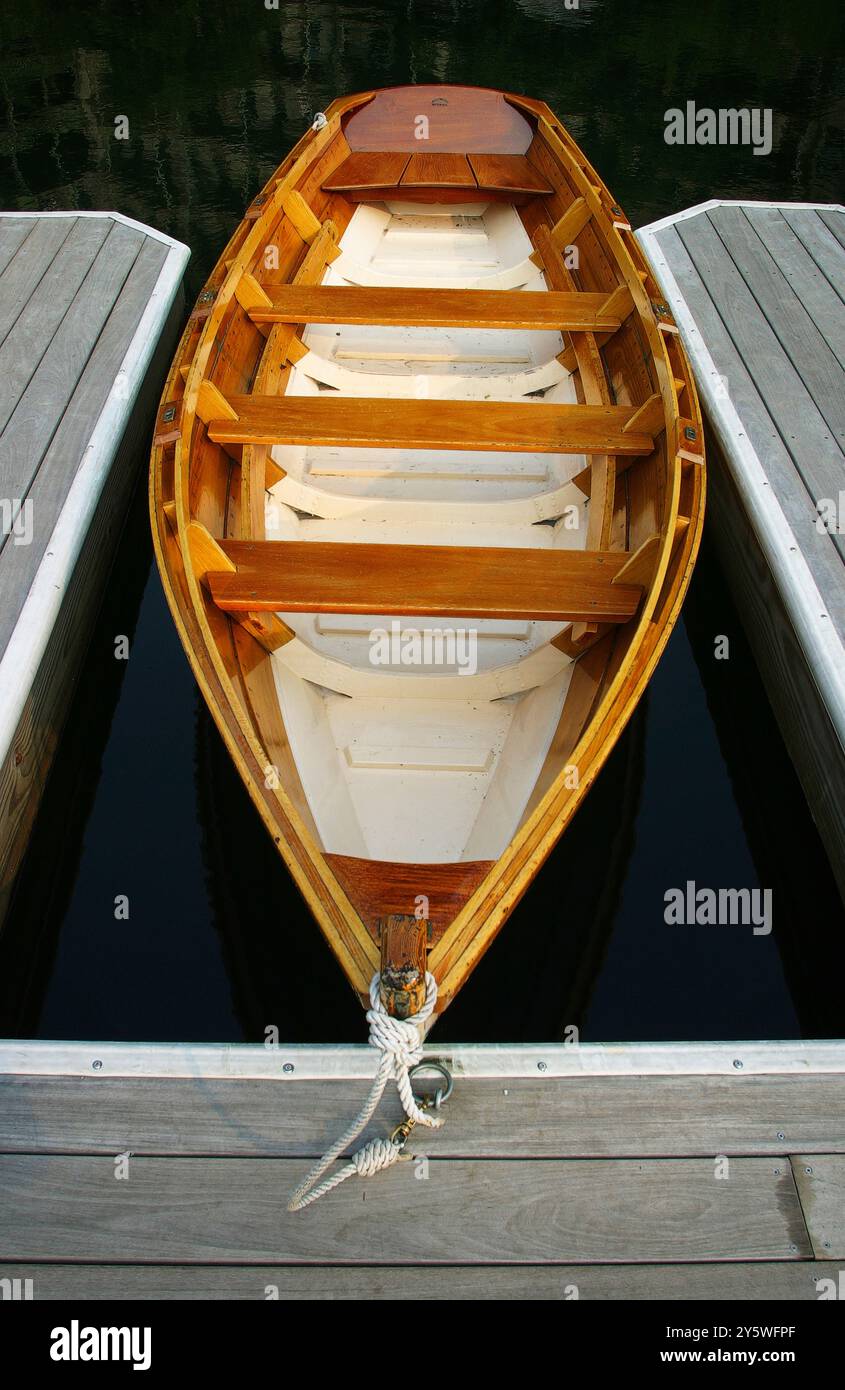 Wooden row boat tied to dock Stock Photo - Alamy