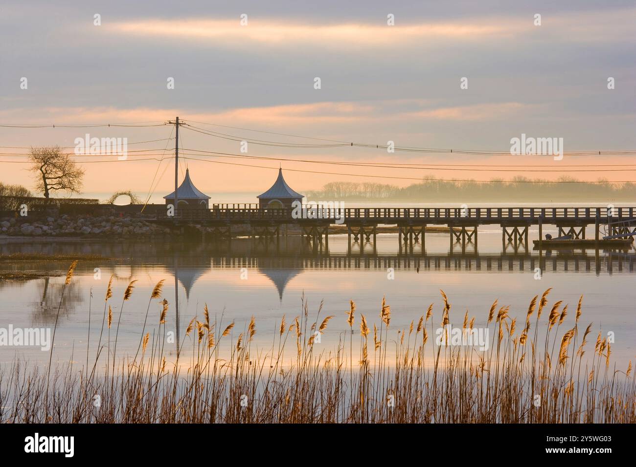 A long, low bridge crosses the water connecting a small coastal island ...