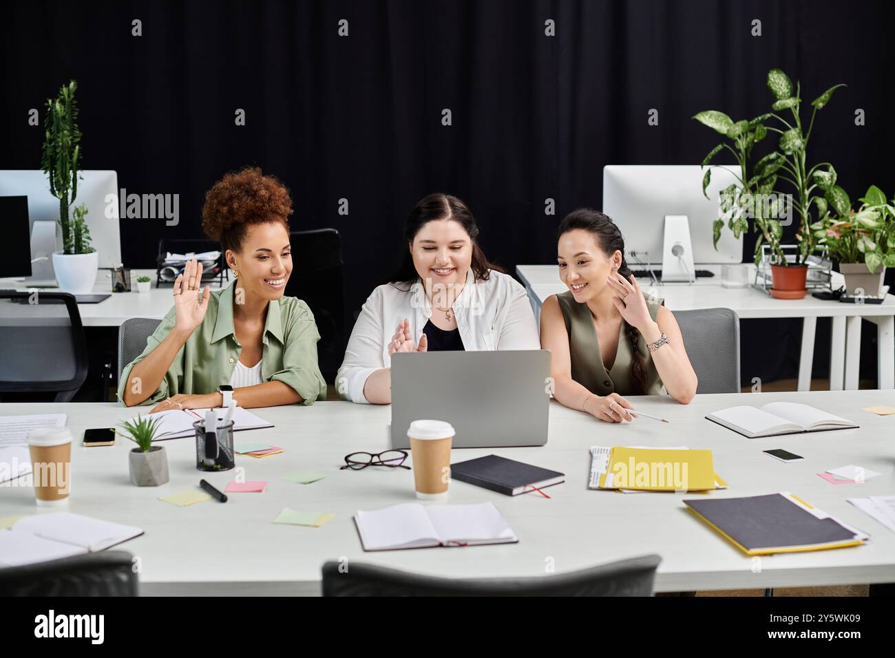 Three professional women are engaged in a lively discussion while ...