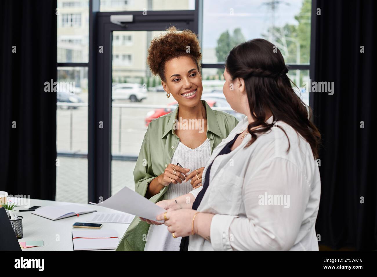 Two professional women discuss ideas, showcasing teamwork and ...