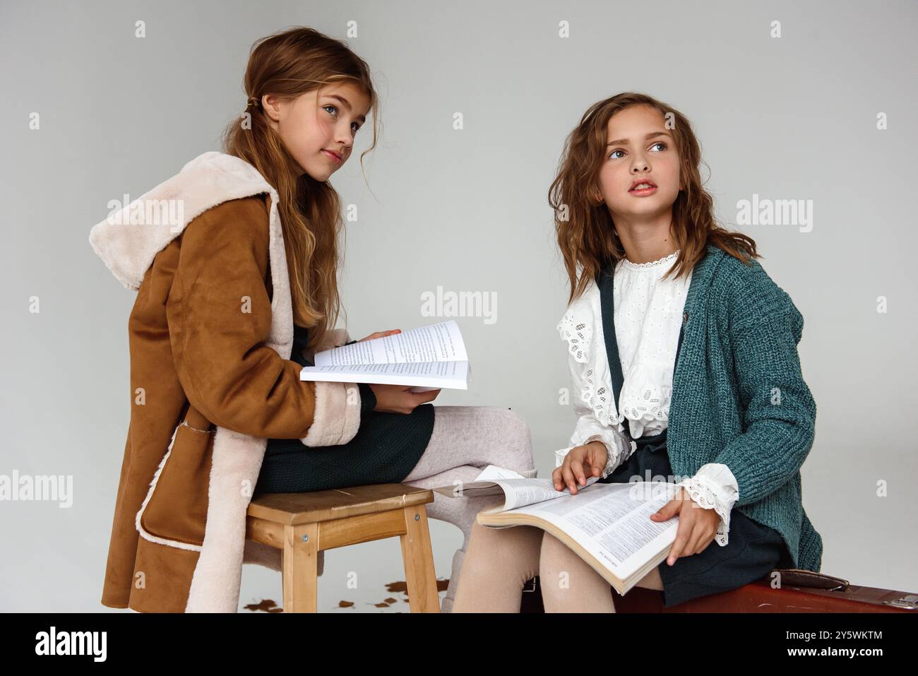 Two young girls reading a book Stock Photo - Alamy