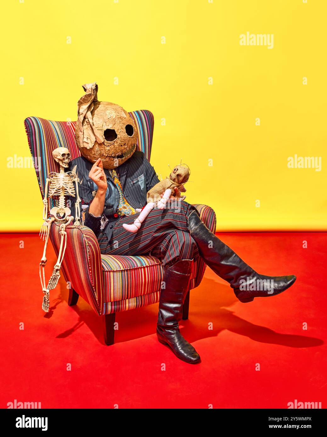 Creepy character in mask and ripped clothes sitting in armchair with ...