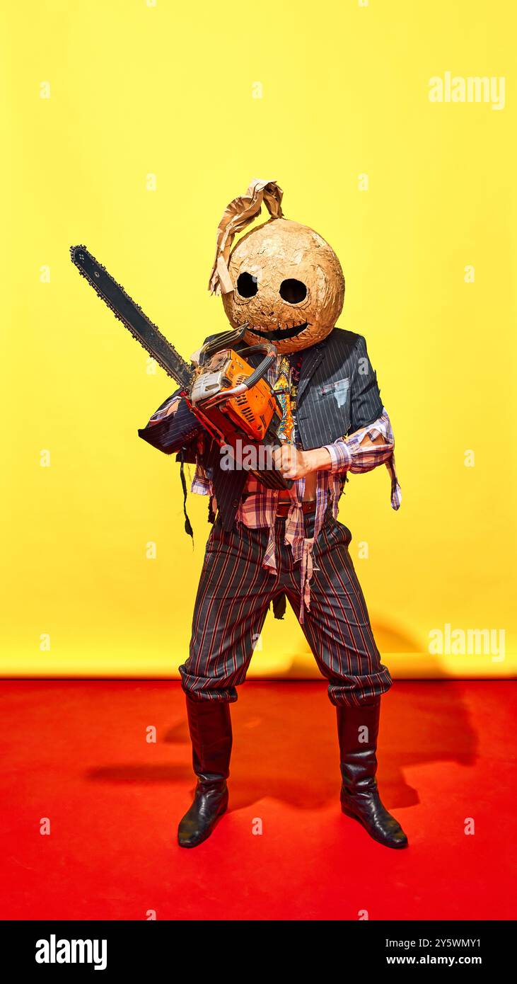 Terrifying character in ripped clothes and creepy mask, standing with ...