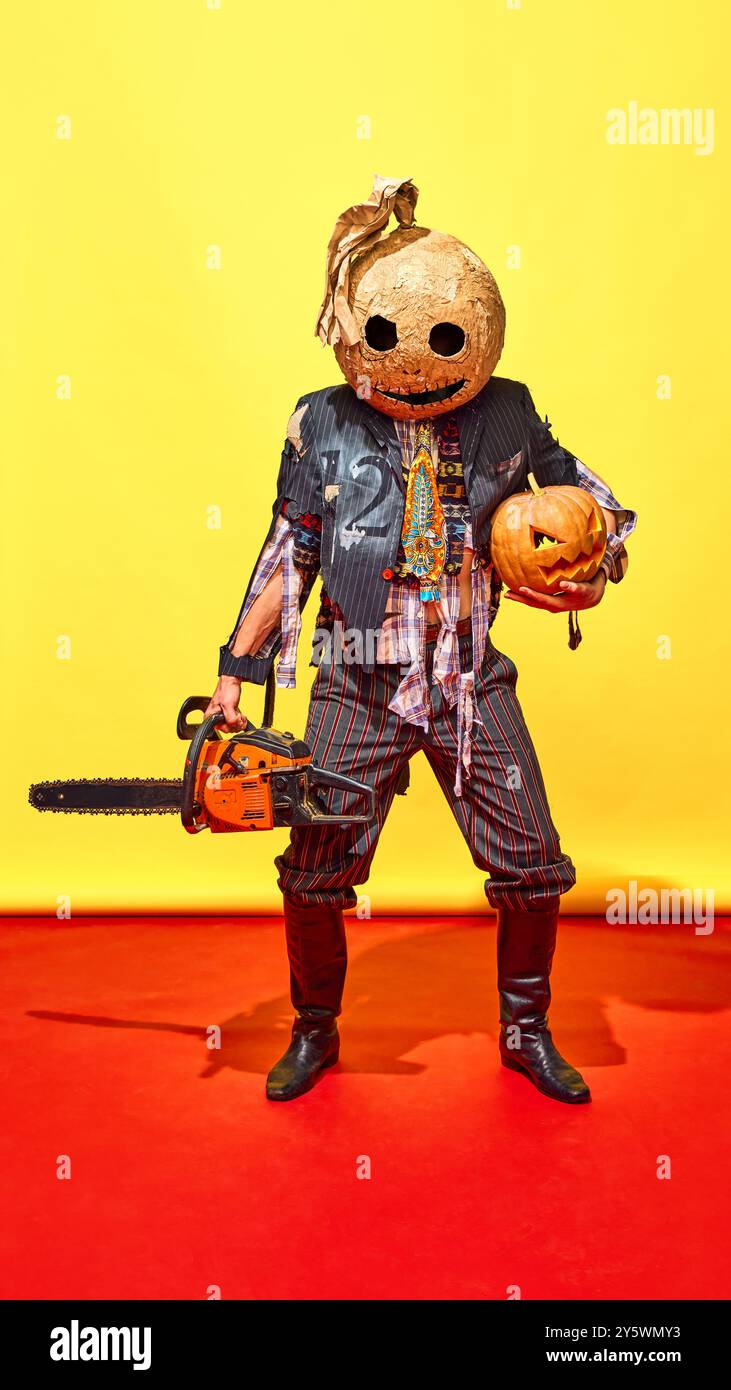 Terrifying character in ripped clothes and creepy mask, standing with ...