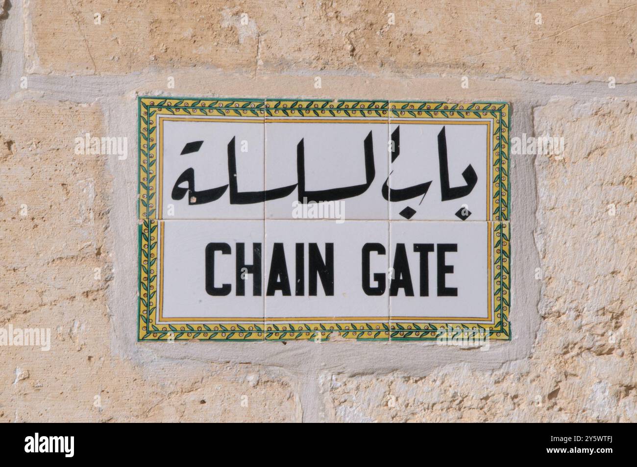 A ceramic tile street sign in Arabic and English which reads Chain Gate ...