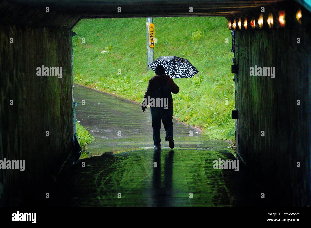 A person shelters from the rain in a flooded underpass by Lawrence Hill ...