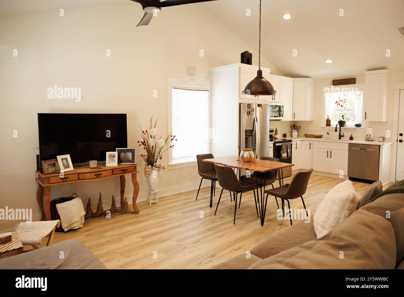 Modern living room seamlessly connected to a kitchen with contemporary furniture and wood ...