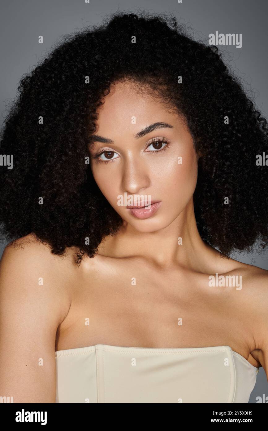 A fashionable woman with stunning curls poses elegantly, radiating ...