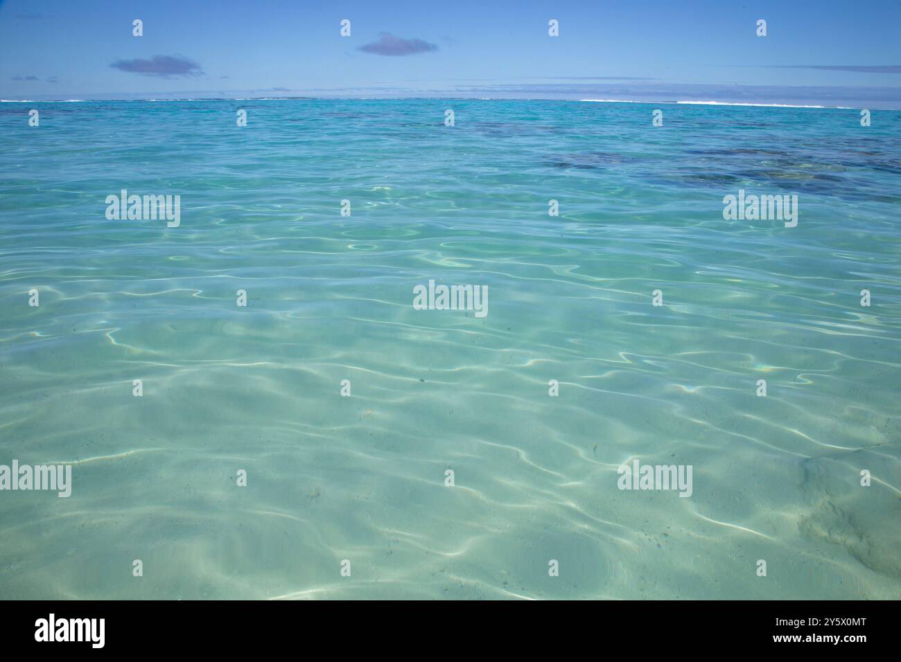 Clear turquoise waters gently wash over white sandy beach under a ...