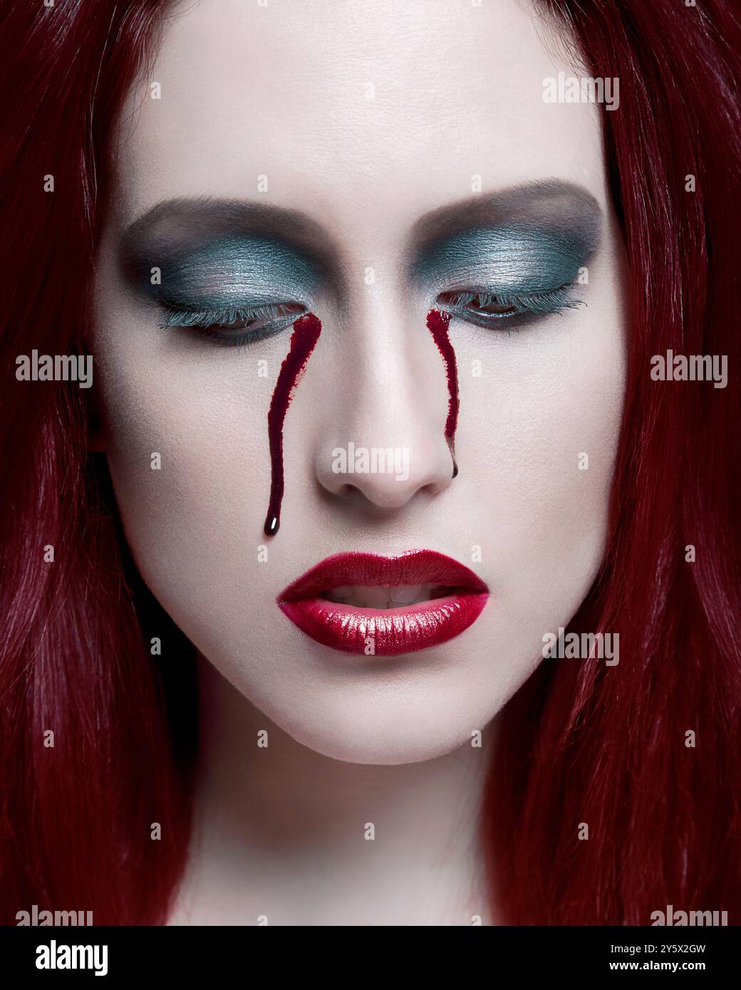 Close-up of a woman with red hair, dramatic blue eyeshadow, and tears ...
