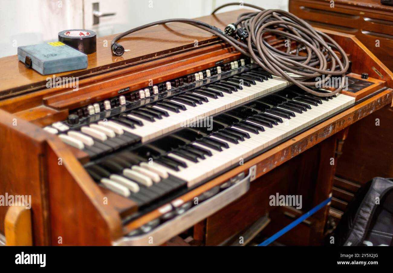 Vintage electric organ with multiple keyboards and a coiled cable on ...
