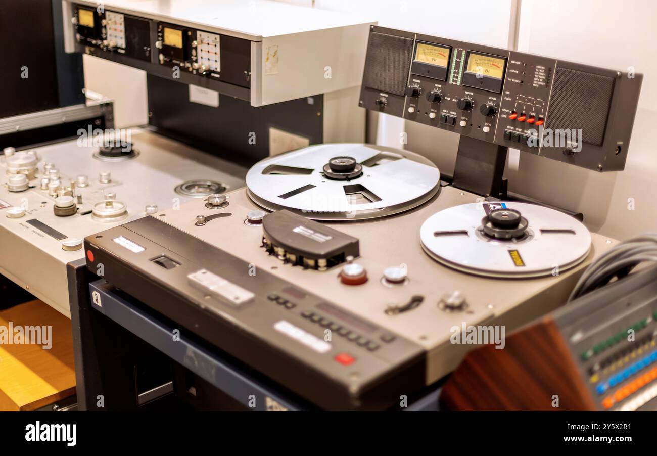 Vintage reel-to-reel tape recorder on a workbench with various control ...