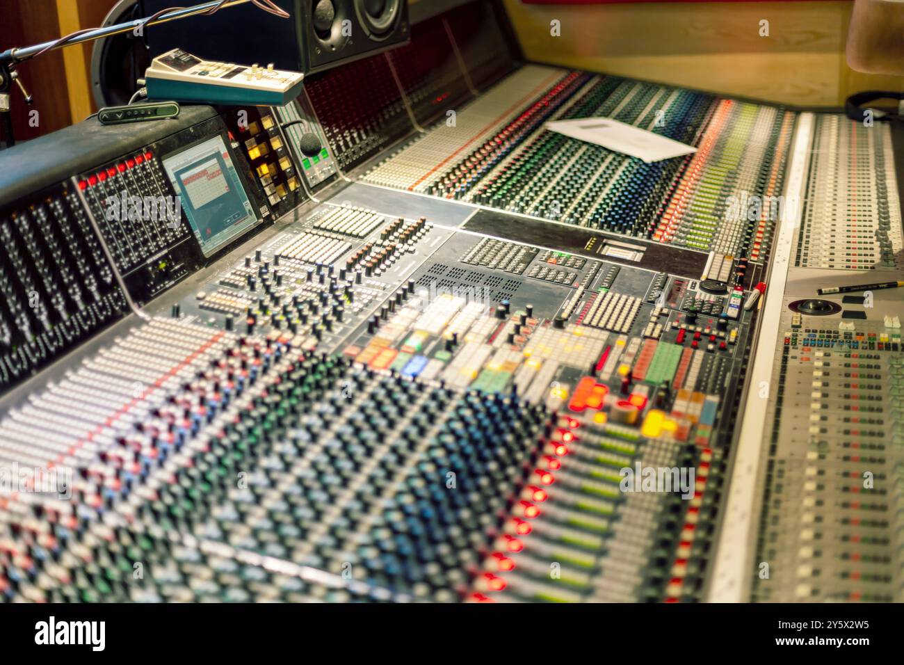 Close-up view of a professional sound mixing console with various knobs ...