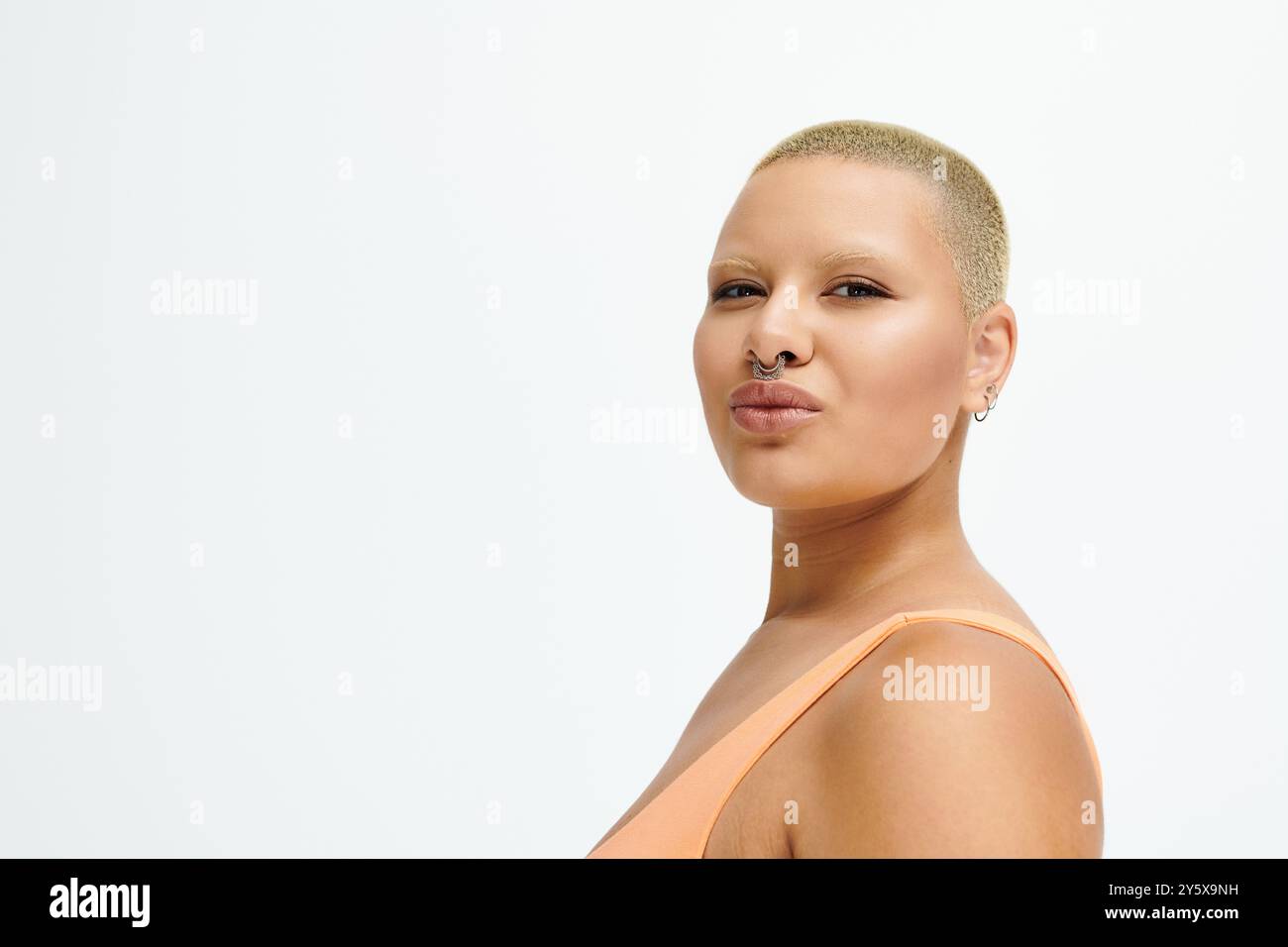 A young bald woman showcases her unique style in vibrant attire with a ...