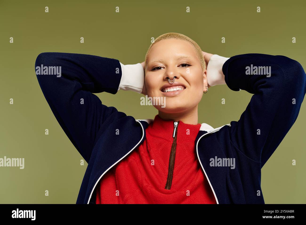 A young bald woman radiates happiness in her bright attire while posing ...