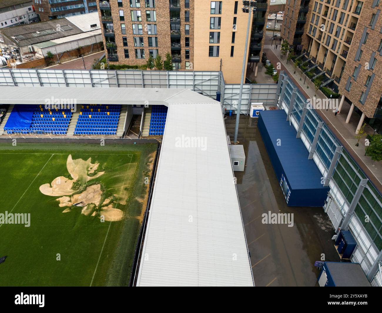 A sinkhole on the pitch (centre left) and flooded walkways (right) at ...