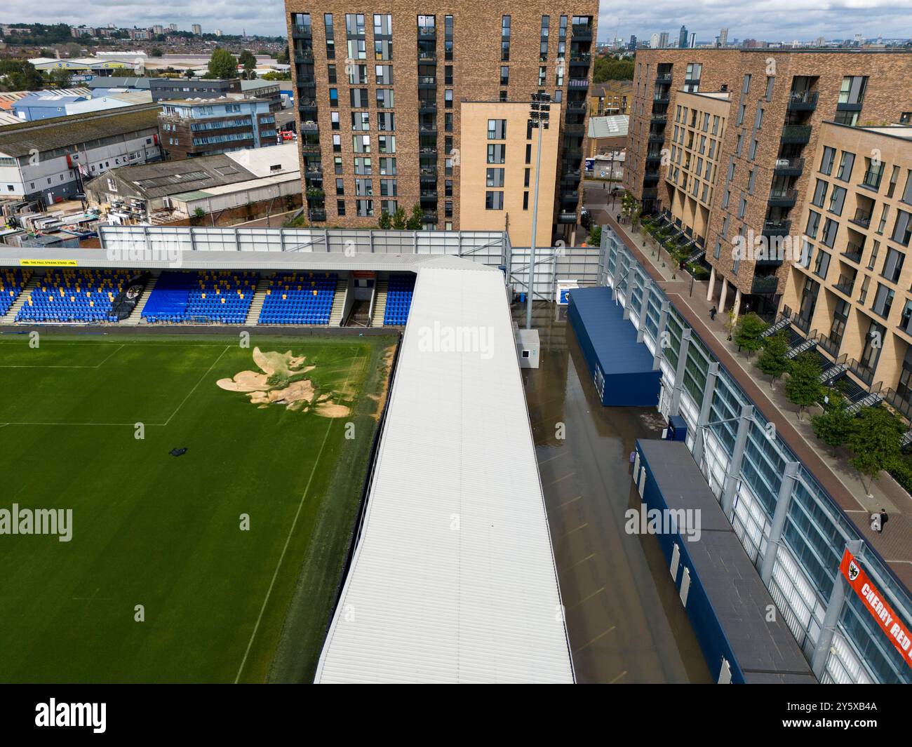 A sinkhole on the pitch (centre left) and flooded walkways (right) at ...