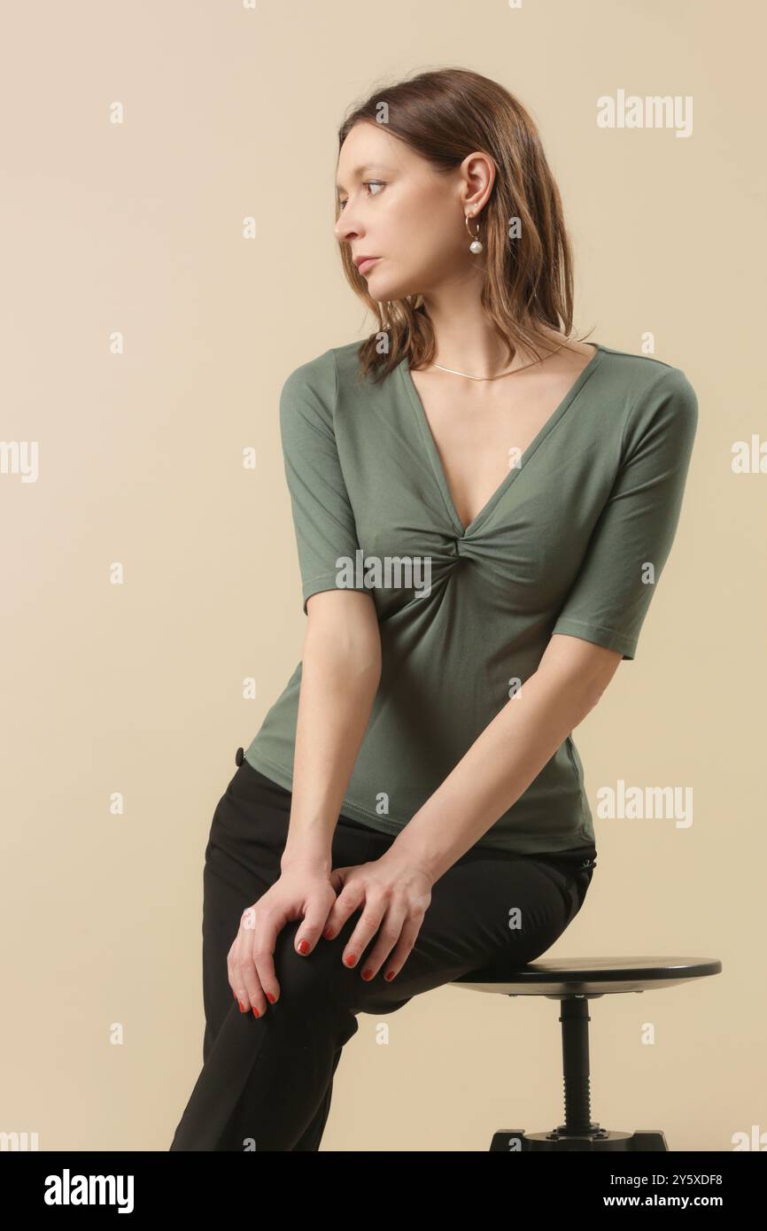 Female model wearing green cotton shirt and smart casual black tousers ...
