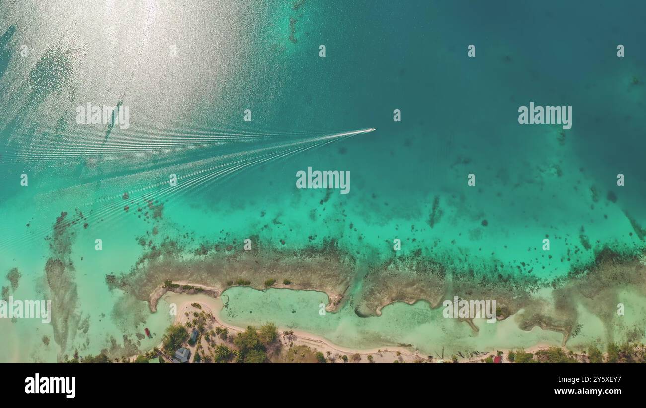 Aerial top down view speedboat leaving white trail on turquoise crystal ...