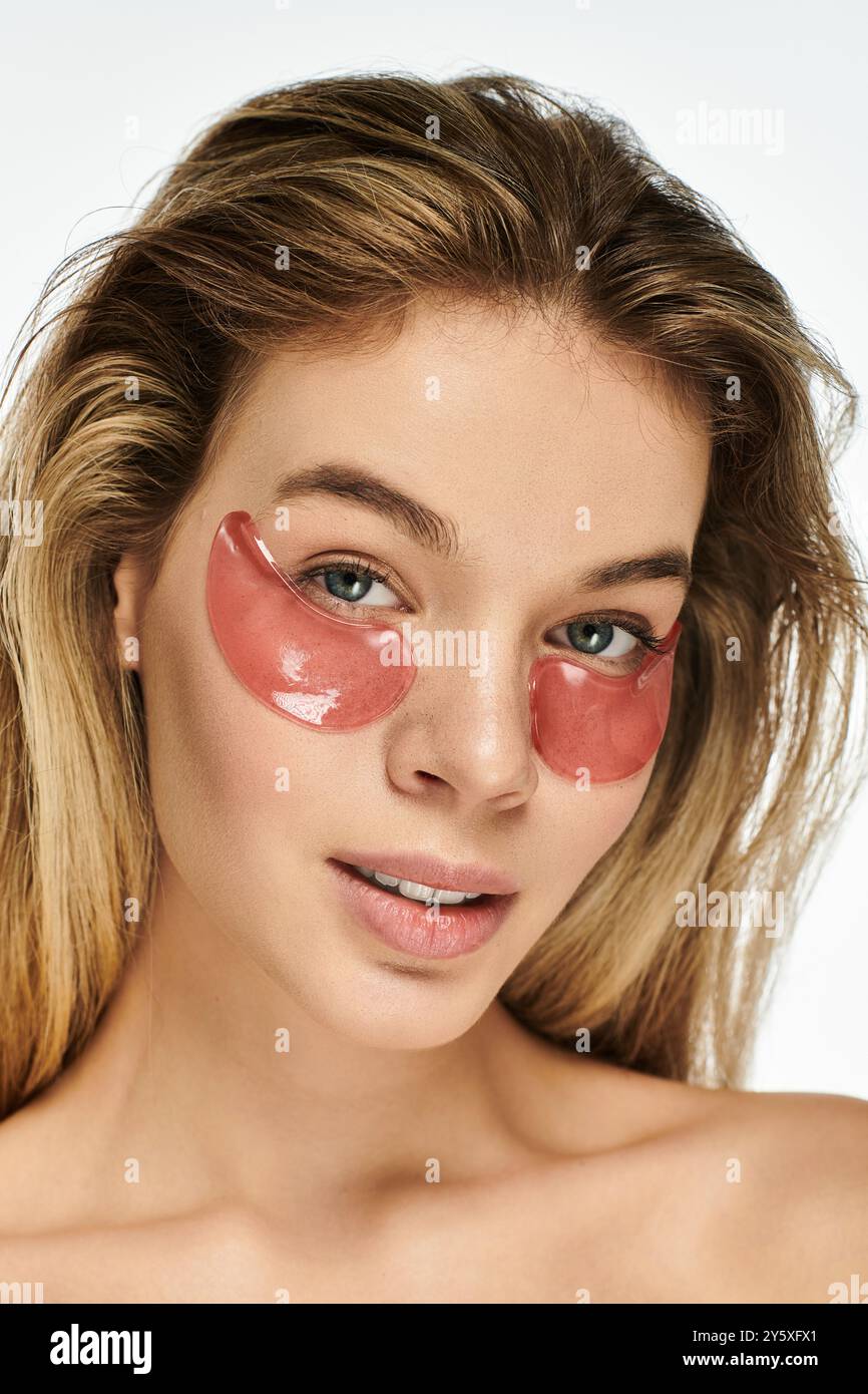 A beautiful young woman relaxes with soothing eye patches, enhancing ...