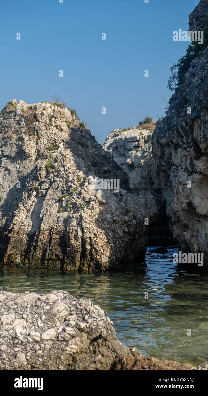 Clear water reveals unique rock formations along the coast, with a calm ...