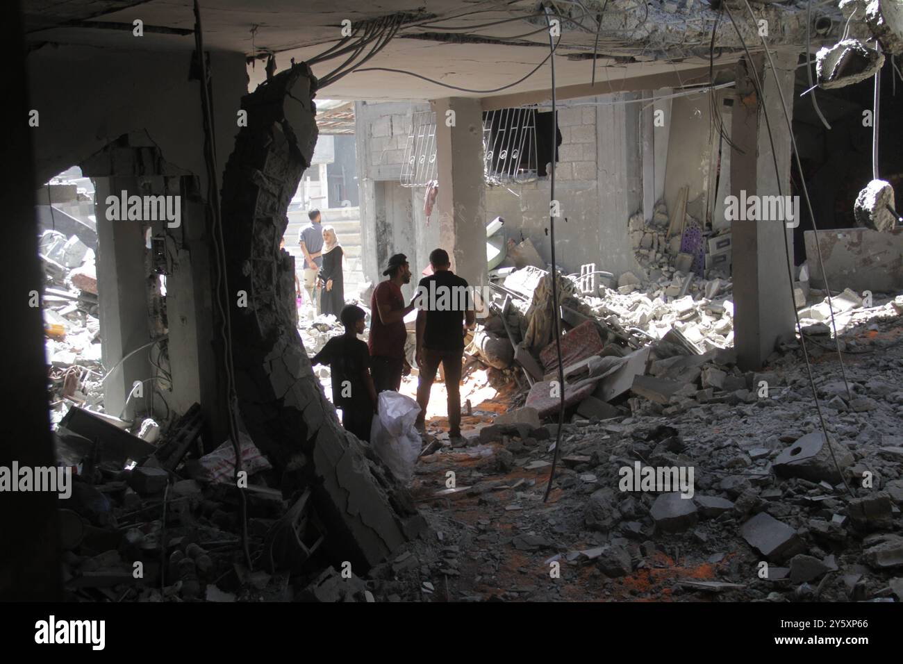 Palestinian people investigate the destroyed buildings after an Israeli ...