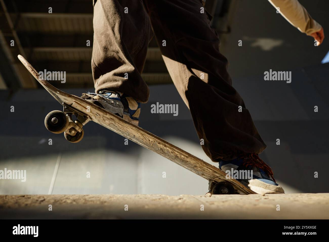 Skateboarder performing trick on concrete ramp in skatepark under large ...