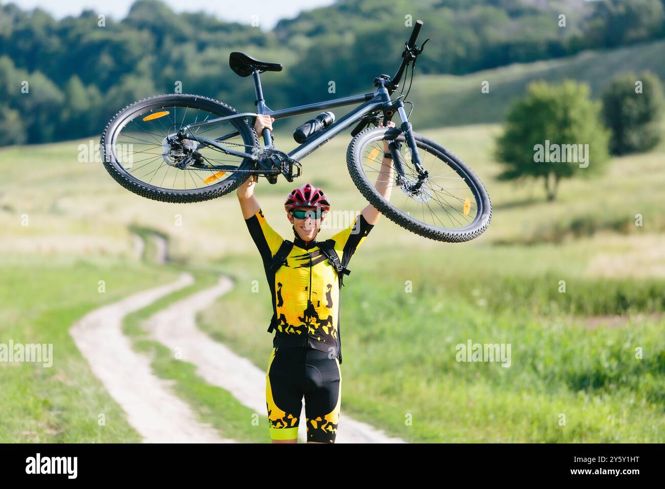 A cyclist in sportswear poses with his mountain bike Stock Photo - Alamy