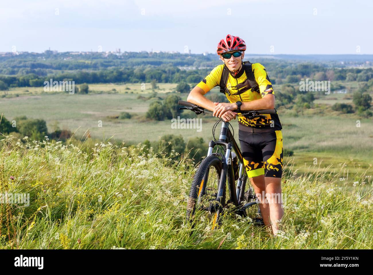 A cyclist in sportswear poses with his mountain bike Stock Photo - Alamy