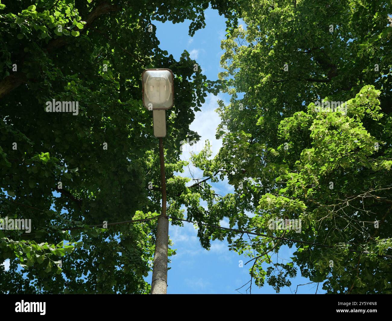 an old deteriorated street lamp from DDR times. The damaged concrete ...