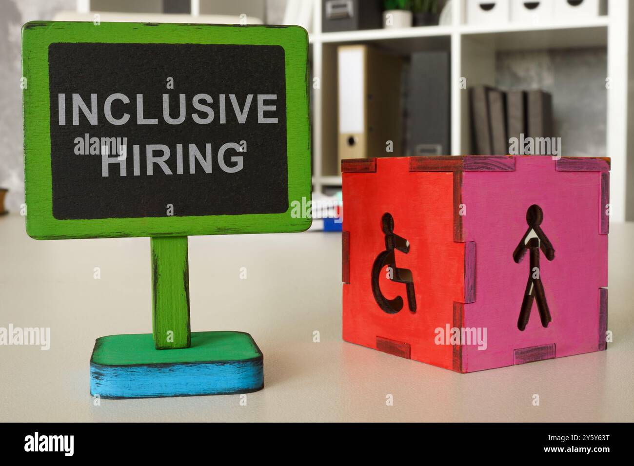 Office desk with an inclusive hiring sign. Represents diversity in the ...