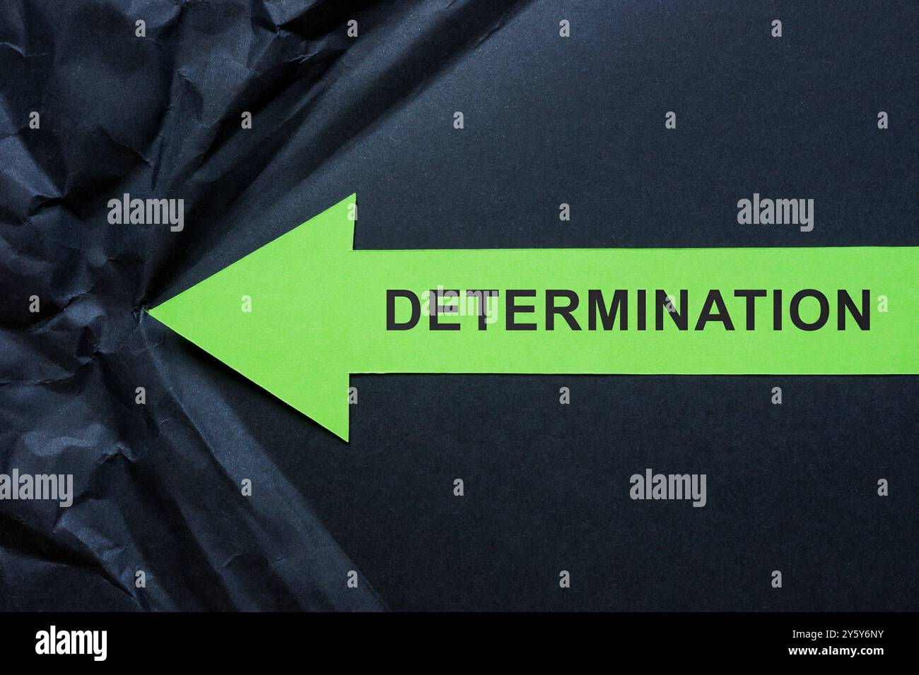 Determination with crumpled paper and an arrow. Symbolizes perseverance ...