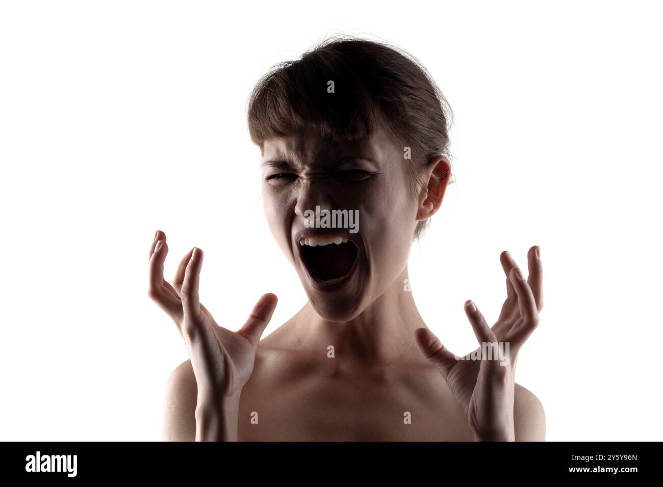 Dramatic silhouette of a young woman screaming, showing extreme stress ...