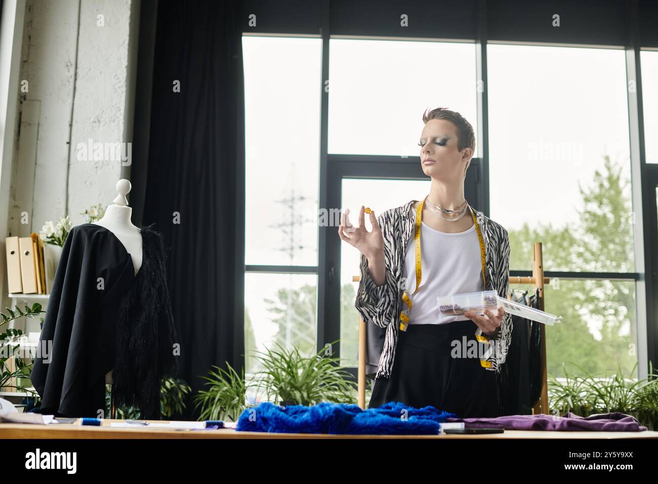 A stylish gender fluid fashion designer curates vibrant materials while ...