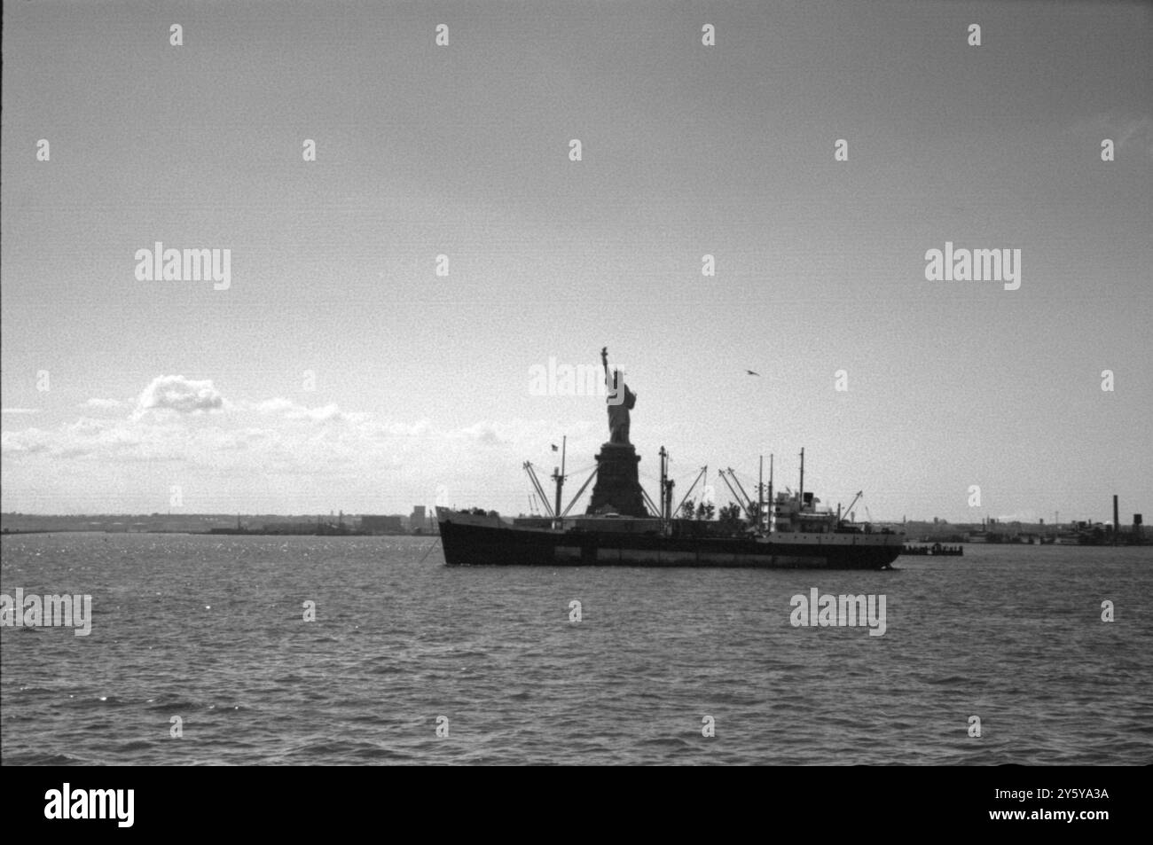 The Statue of Liberty and a cargo ship in the New York City harbor C ...