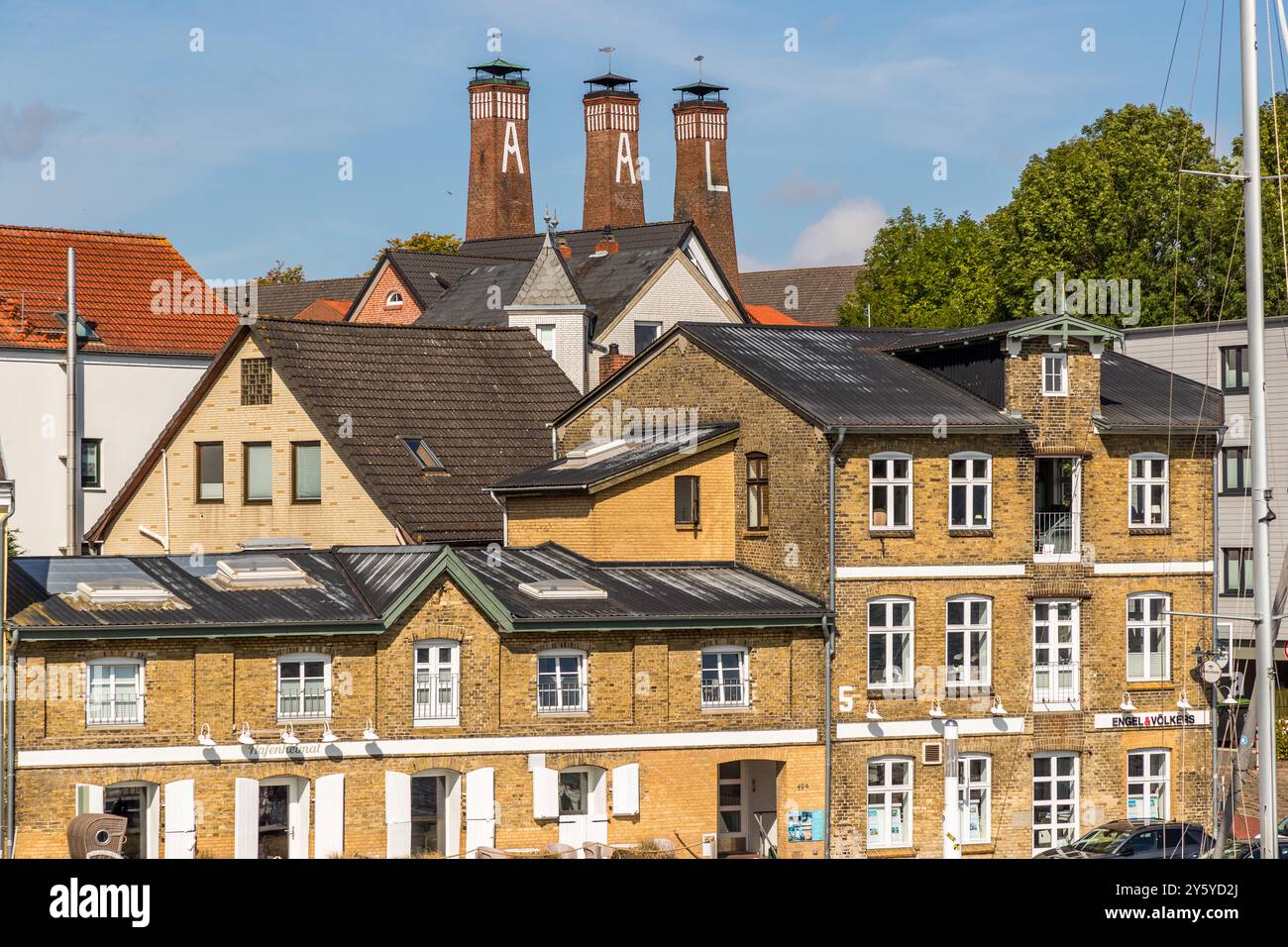 Houses on the harbor promenade of Kappeln with the three towers of the ...