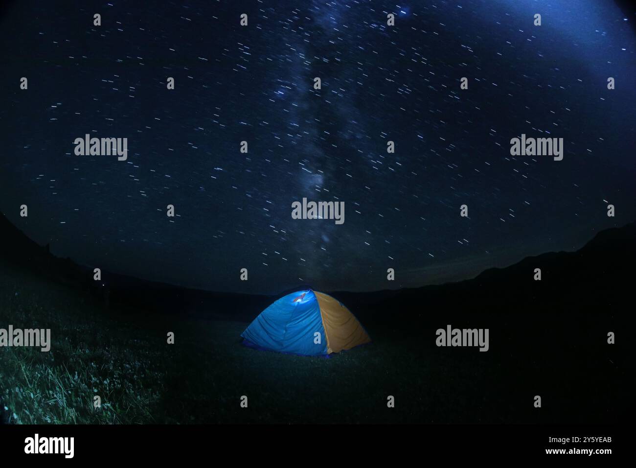 Modern camping tent in wilderness at night, slow shutter speed effect ...