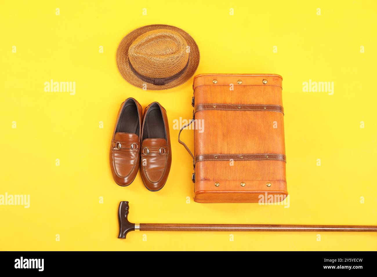 Suitcase, shoes, hat and cane on yellow background, flat lay Stock ...