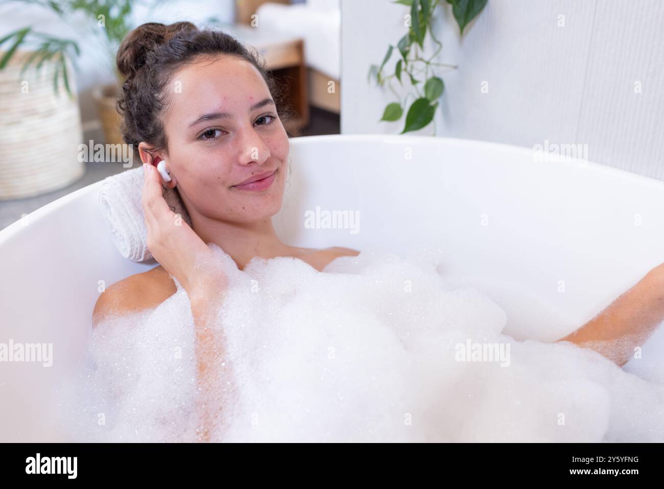 Relaxing in bathtub with foam, woman enjoying spa treatment at home ...